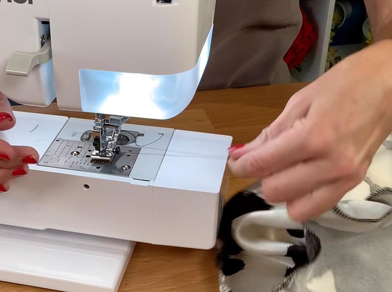 Pull the threads with one hand while guiding the fabric with the other ...